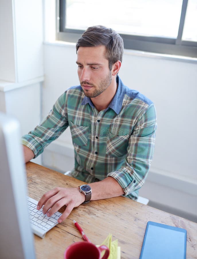 Hes always Hard at Work. a Handsome Young Man Working on His Pc in the ...