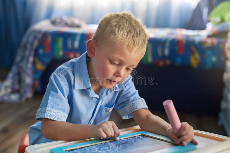 Hes Such a Creative Little Kid. a Little Boy Writing on a Chalkboard at ...