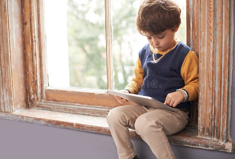 Hes Tech Savvy Already. a Cute Little Boy Using a Tablet while Sitting ...
