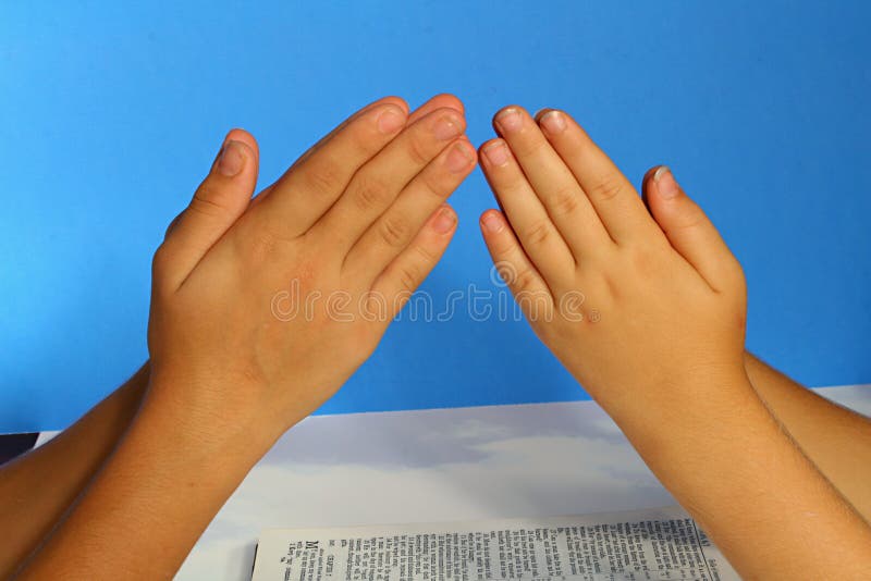 Het bidden handen op blauw stock afbeelding. Image of mensen - 1356349