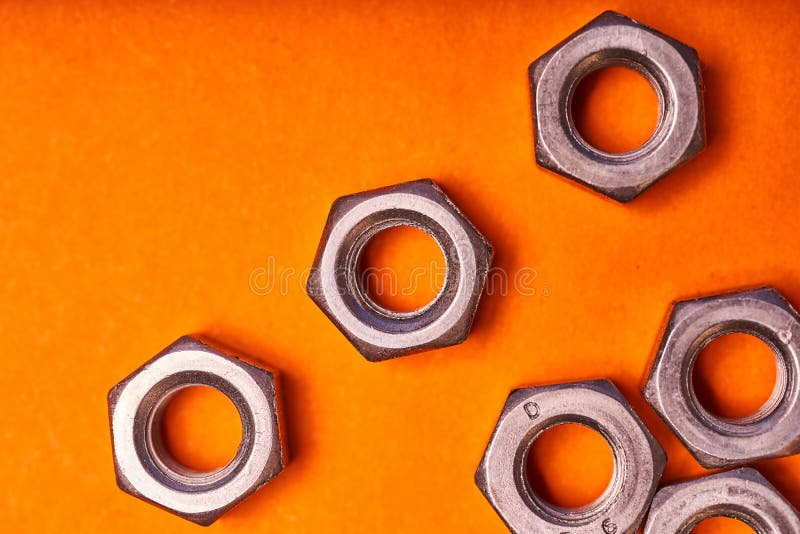 Hex Nuts on Orange Background. Bolted Connection Elements Stock Photo ...