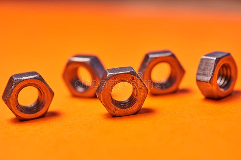 Hex Nuts on Orange Background. Bolted Connection Elements Stock Image ...