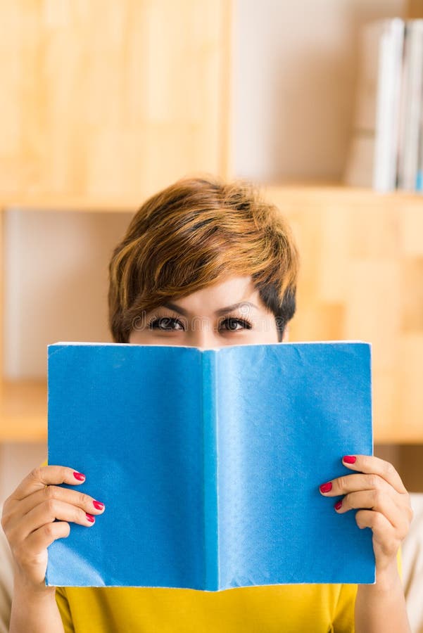 Hiding behind a book stock photo. Image of indoors, smiling - 56181576