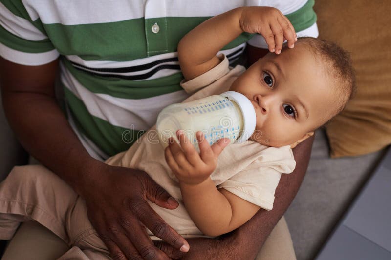 High Angle Cute Baby Boy Drinking Milk Bottle and Looking at Camera ...