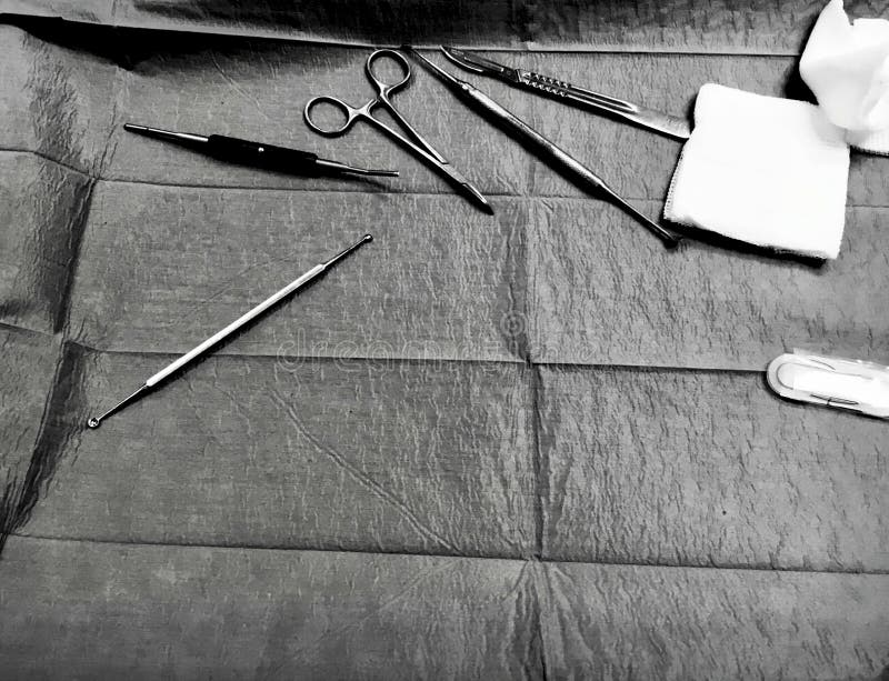 High Angle Greyscale Shot of Surgical Instruments on a Dark Surface ...