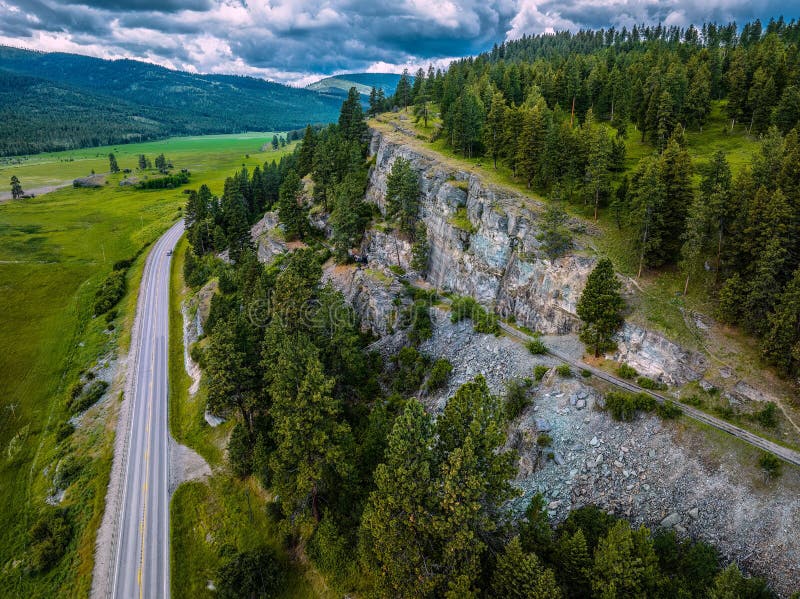 High-angle Scenery of a High Cliff with Pine Trees Above a Long Highway ...