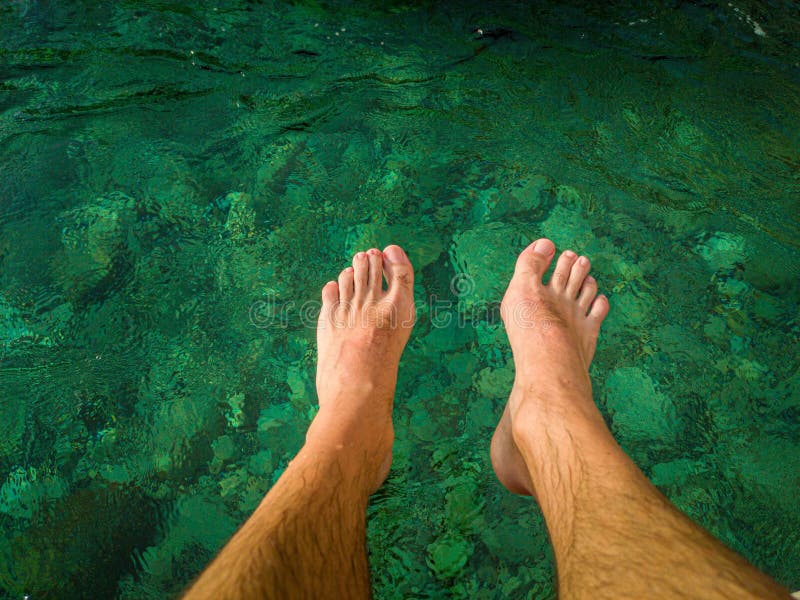 High Angle Shot of Bare Feet Hanging Over a Green Sea Stock Image ...