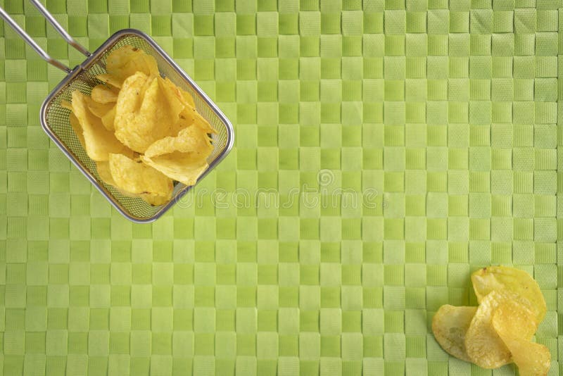High Angle Shot of a Basket of Potato Chips on a Woven Green Surface ...
