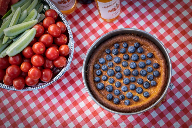 High Angle Shot of a Blueberry Pie with Red Tomatoes on the Side ...