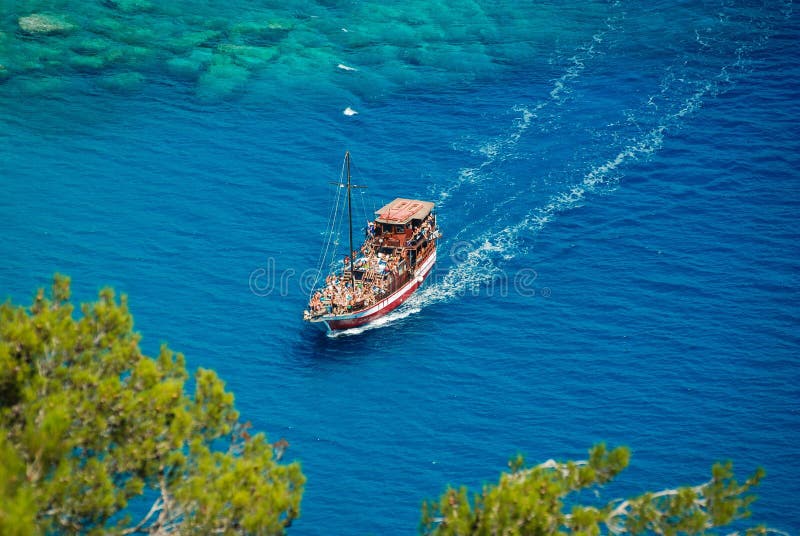 High-angle Shot of a Boat with People Floating on the Blue Water S ...