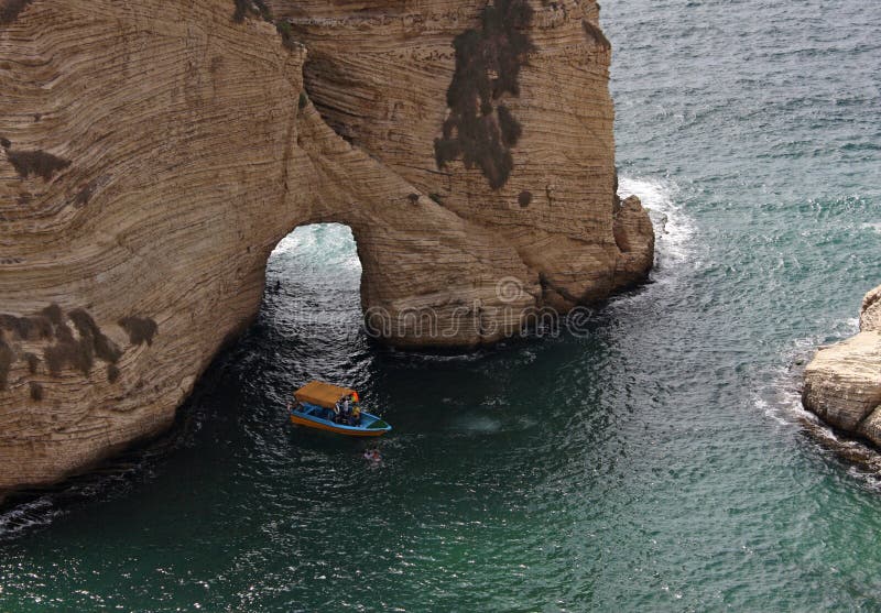 High Angle Shot of a Boat Sailing on the Water Next To a Large Cliff ...