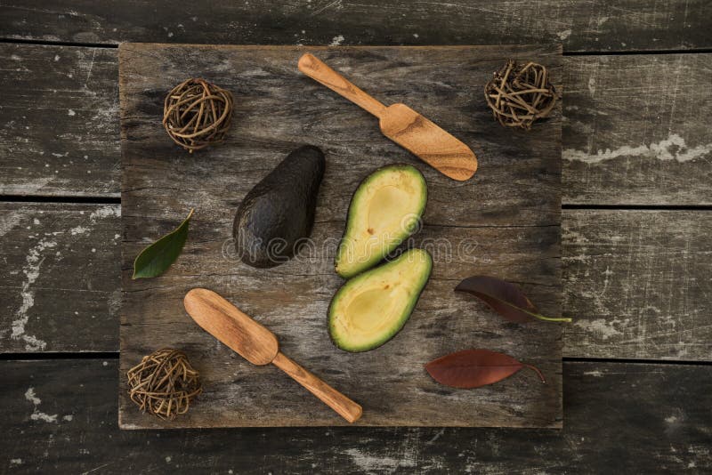 High Angle Shot of Cut Avocados and Wooden Spoons on a Wooden Surface ...