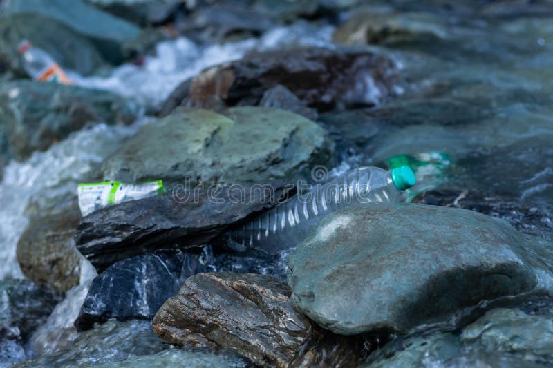 High Angle Shot of Empty Water Bottle and Chips Packet Thrown in River ...