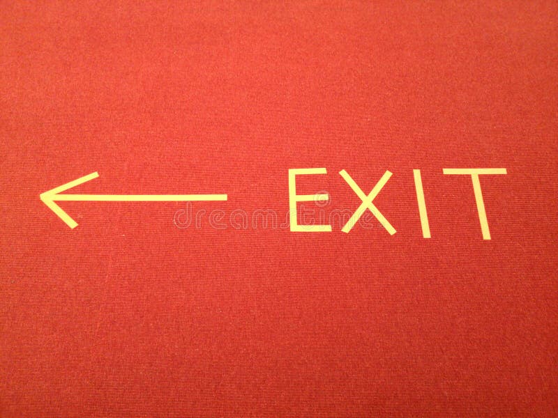 High Angle Shot of an Exit Sign and a Direction Pointer on a Red ...