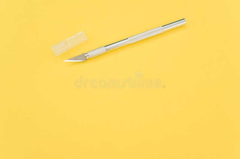 High Angle Shot of Metallic Scalpel with Cap Isolated on Yellow ...