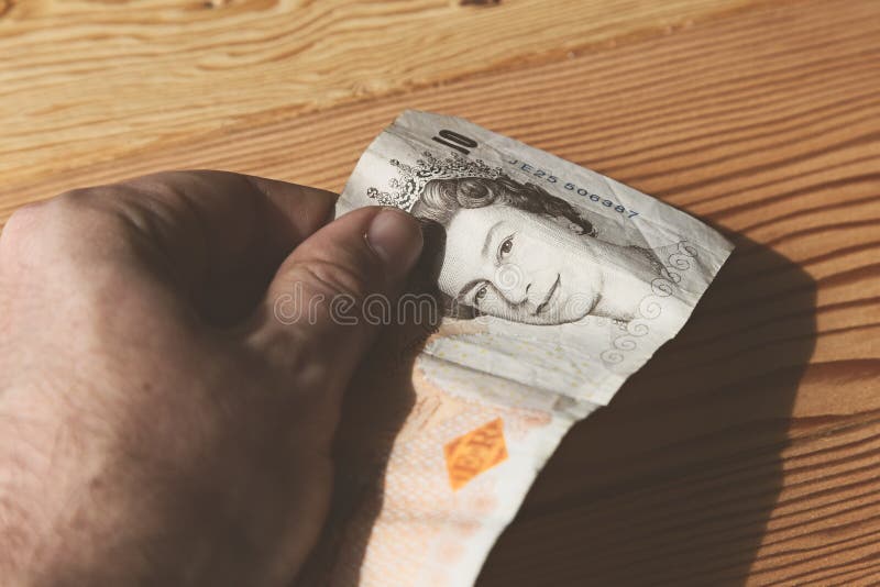 High Angle Shot of a Person Holding a Banknote Over a Wooden Surface ...