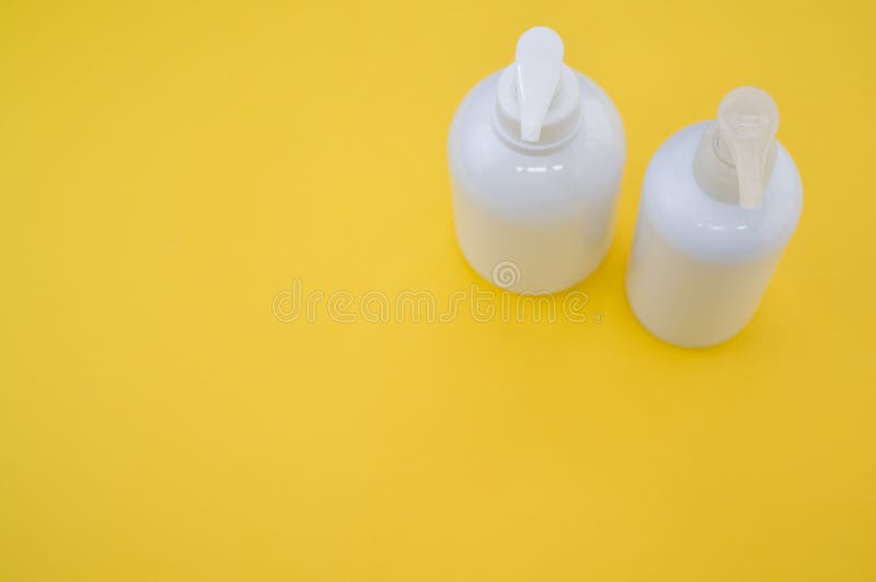 High Angle Shot of Plastic Bottles with Pumps on a Yellow Surface Under ...