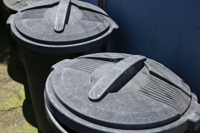 High Angle Shot of Plastic Garbage Cans Next To a Building Captured at ...