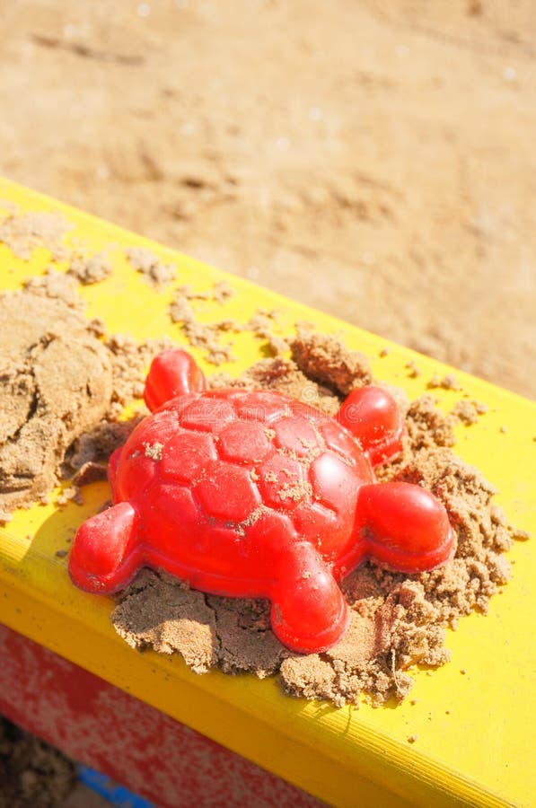 High Angle Shot of a Red Plastic Toy Sand Form in a Turtle Shape on the ...