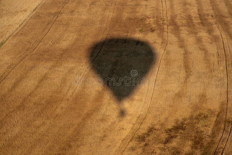 High Angle Shot of the Shadow of a Hot Air Balloon on a Rural Field ...