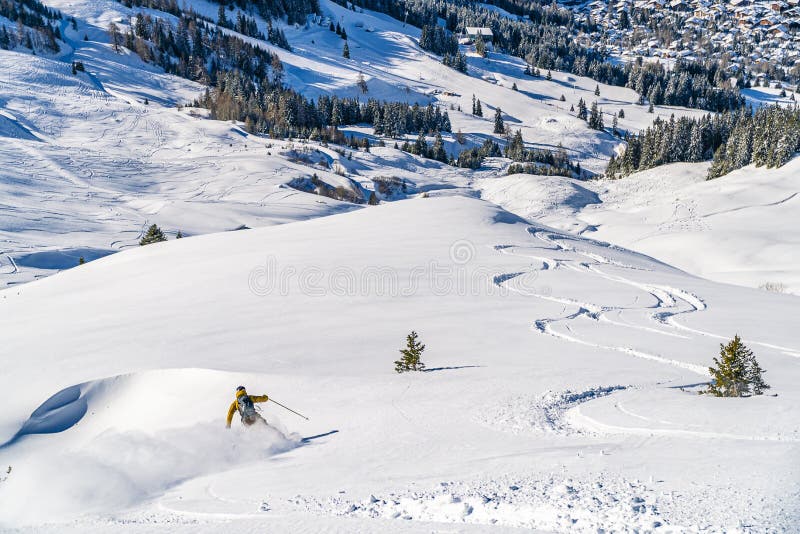 High Angle Shot of a Ski Resort with Ski Tracks and a Skier Going Down ...