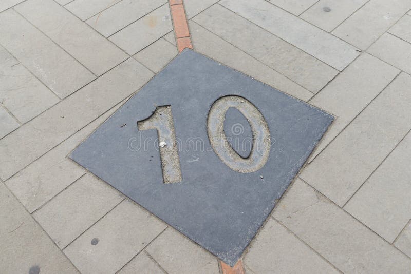 High Angle Shot of a Ten Number Sign on a Tiled Ground Stock Image ...