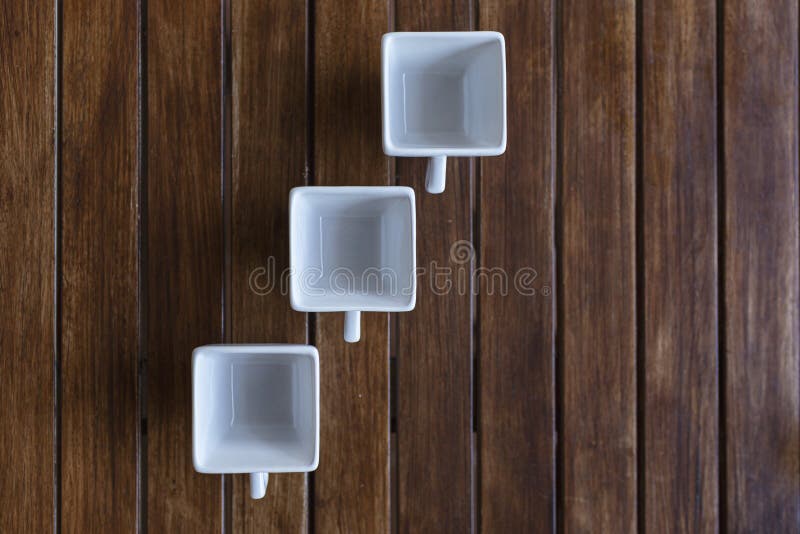 High Angle Shot of Three White Square Cups on a Wooden Surface Stock ...