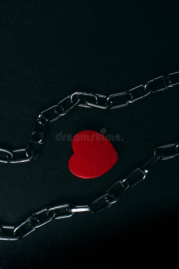 High Angle Shot of a Wooden Red Heart and Metal Chains on a Black ...