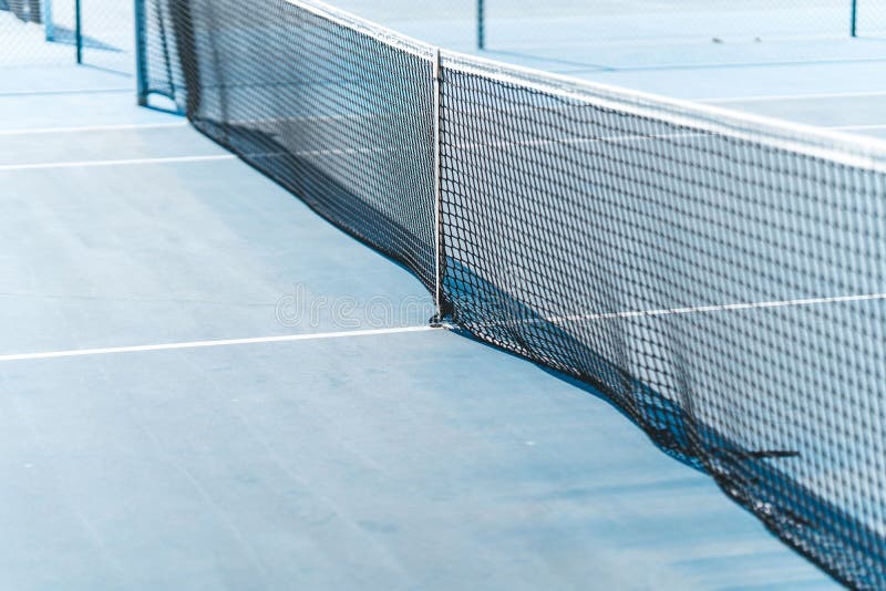 High-angle of a Sunlit, Blue Tennis Court with a Net Stock Photo ...