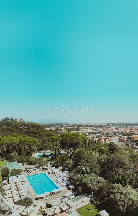 High Angle Vertical Shot of a Pool Surrounded by Trees with Buildings ...