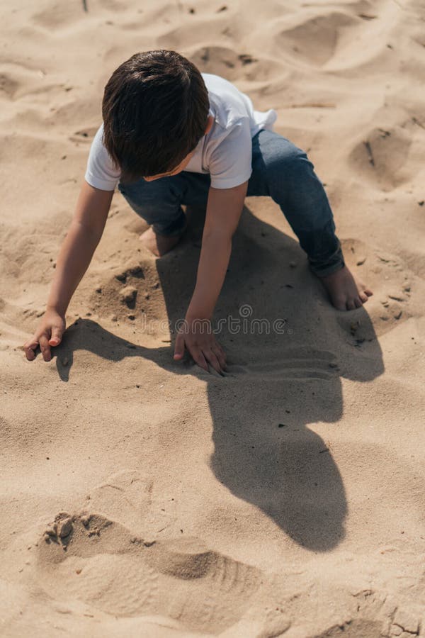 Angle View of Boy Sitting and Touching Sand Stock Image - Image of ...