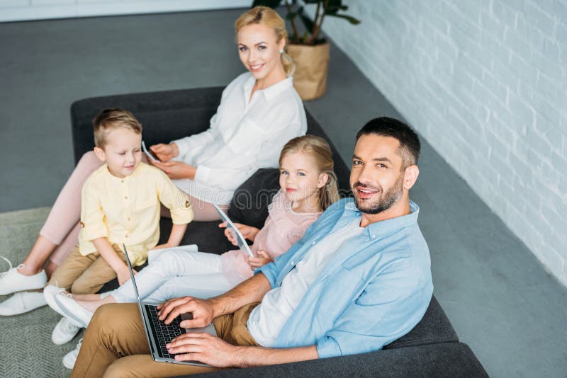 High Angle View of Happy Family Using Digital Devices and Smiling Stock ...