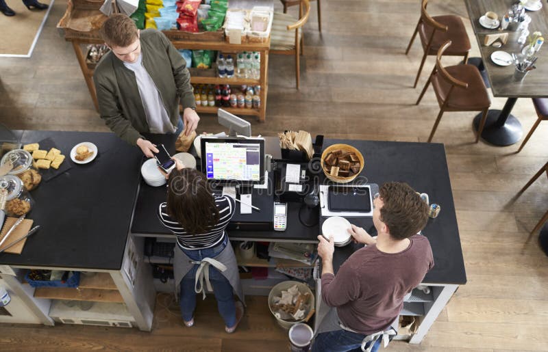 High Angle View of Man Paying Over Counter at a Coffee Shop Stock Photo ...