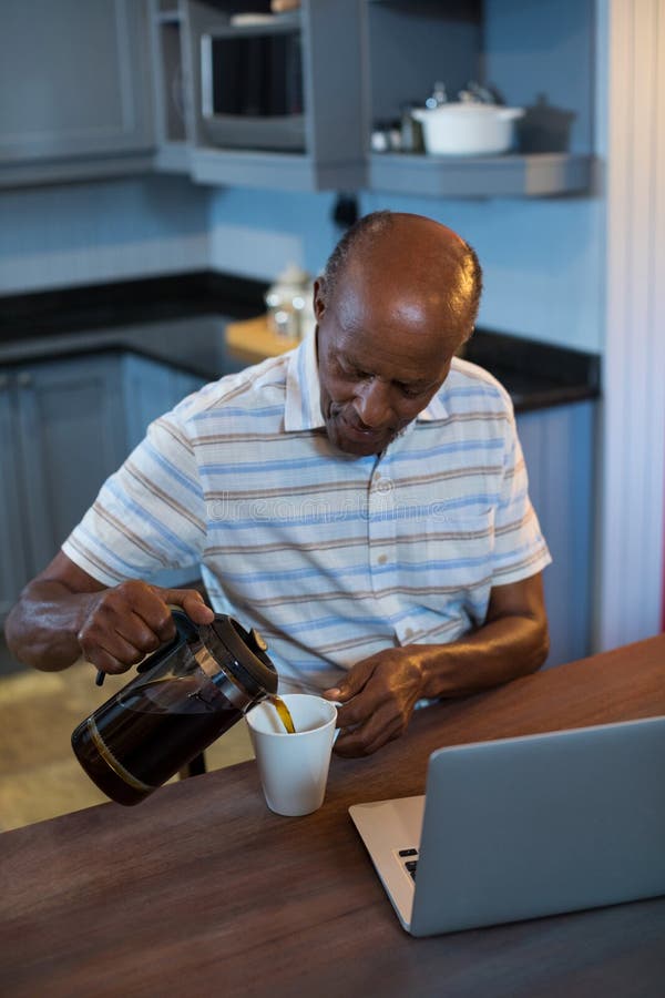 High Angle View of Man Pouring Coffee while Sitting by Laptop Stock ...