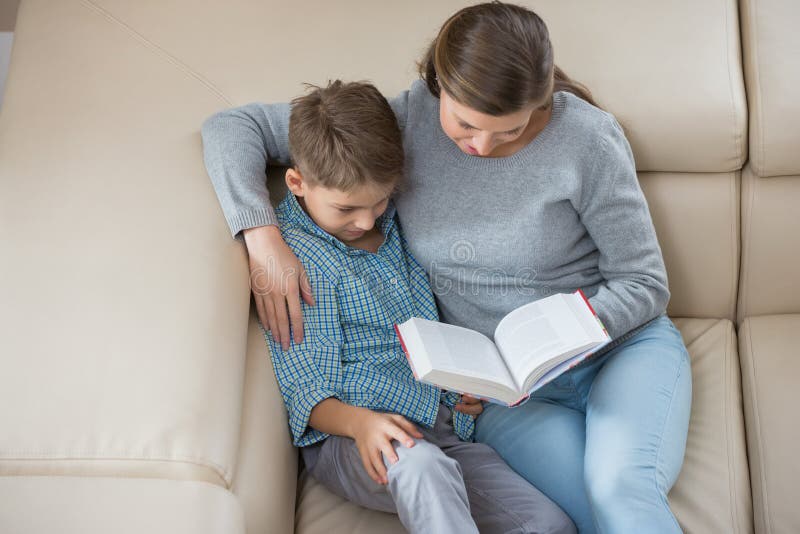 High Angle View of Mother and Son Reading Book on Sofa Stock Image ...