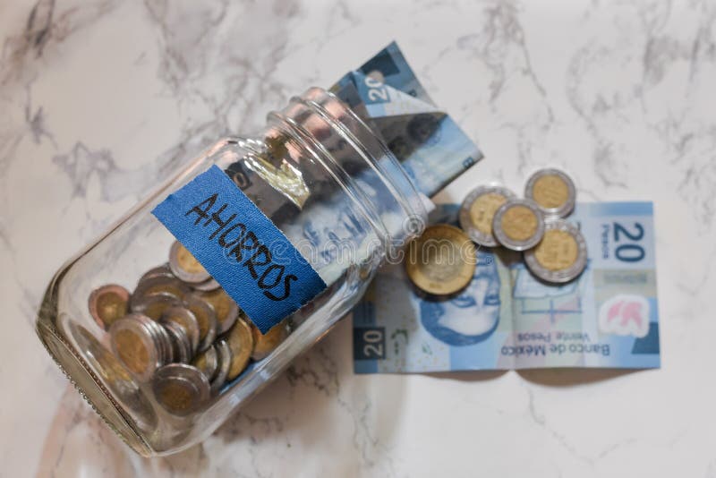 High Angle View of Pesos and Coins in a Jar with a [Ahorros - Savings ...