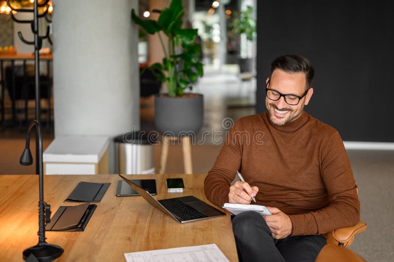 High Angle View of Smiling Businessman Writing Notes while Working Over ...