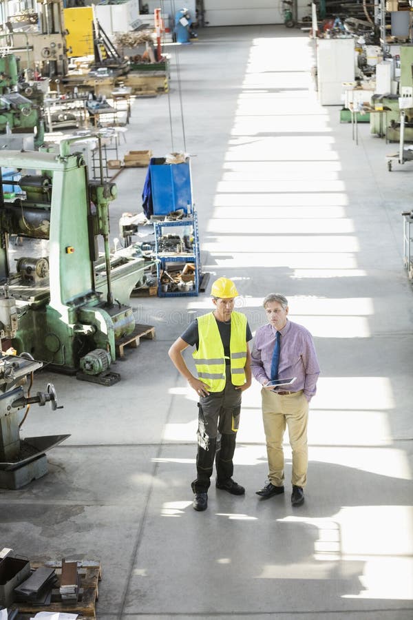 High Angle View of Supervisor and Manual Worker Having Discussion in ...