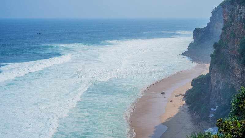 High Cliffs in Front of the Beach, Rolling Sea Waves and White Foam ...