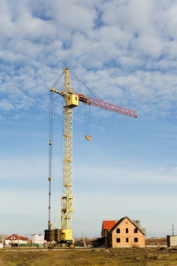High crane and small house stock image. Image of rise - 64432811