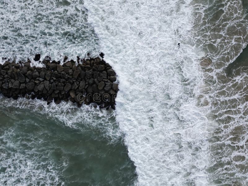 High-definition Aerial Photo of Waves Hitting Rocks on the Beach Stock ...