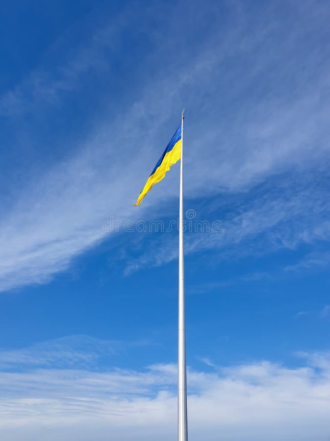 High Flag Post and Ukrainian Yellow and Blue Flag Against Blue Sky with ...