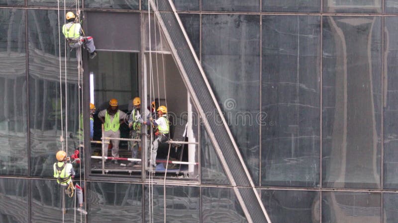 High Maintenance Workers Installing a Window on the Exterior of a ...