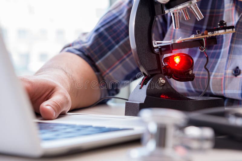 The High Precision Engineering with Man Working with Microscope Stock ...