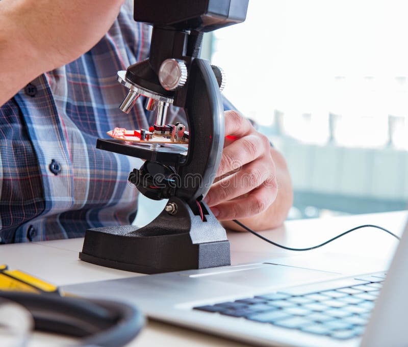 High Precision Engineering with Man Working with Microscope Stock Photo ...
