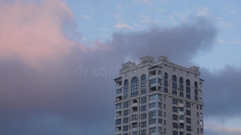 High-rise Building on the Sky Background with Moving Clouds at Sunset ...