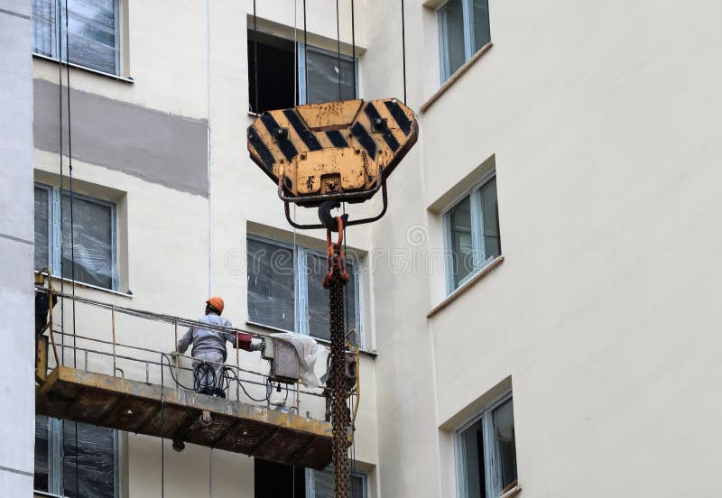 High-Rise Renovation in an Urban Setting with Workers Utilizing a Crane ...