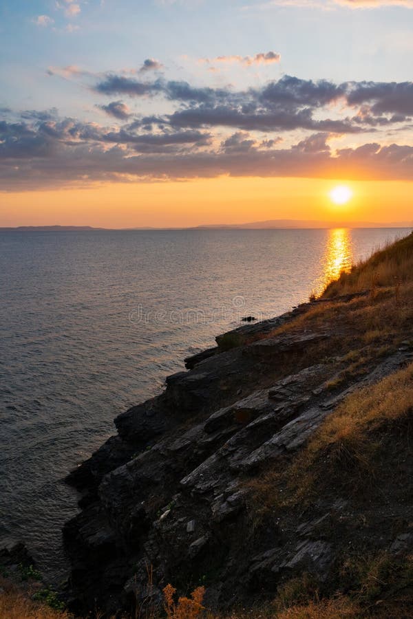 High Rocky Cliffs by the Sea with Colorful Warm Sunset Beneath the ...