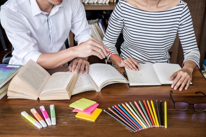 High School or College Student Group Sitting at Desk in Library ...