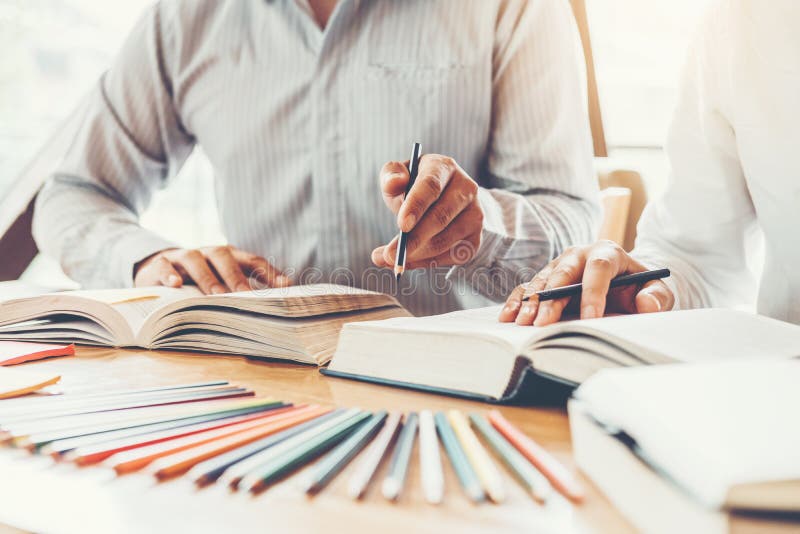 High School or College Students Studying and Reading Together in ...